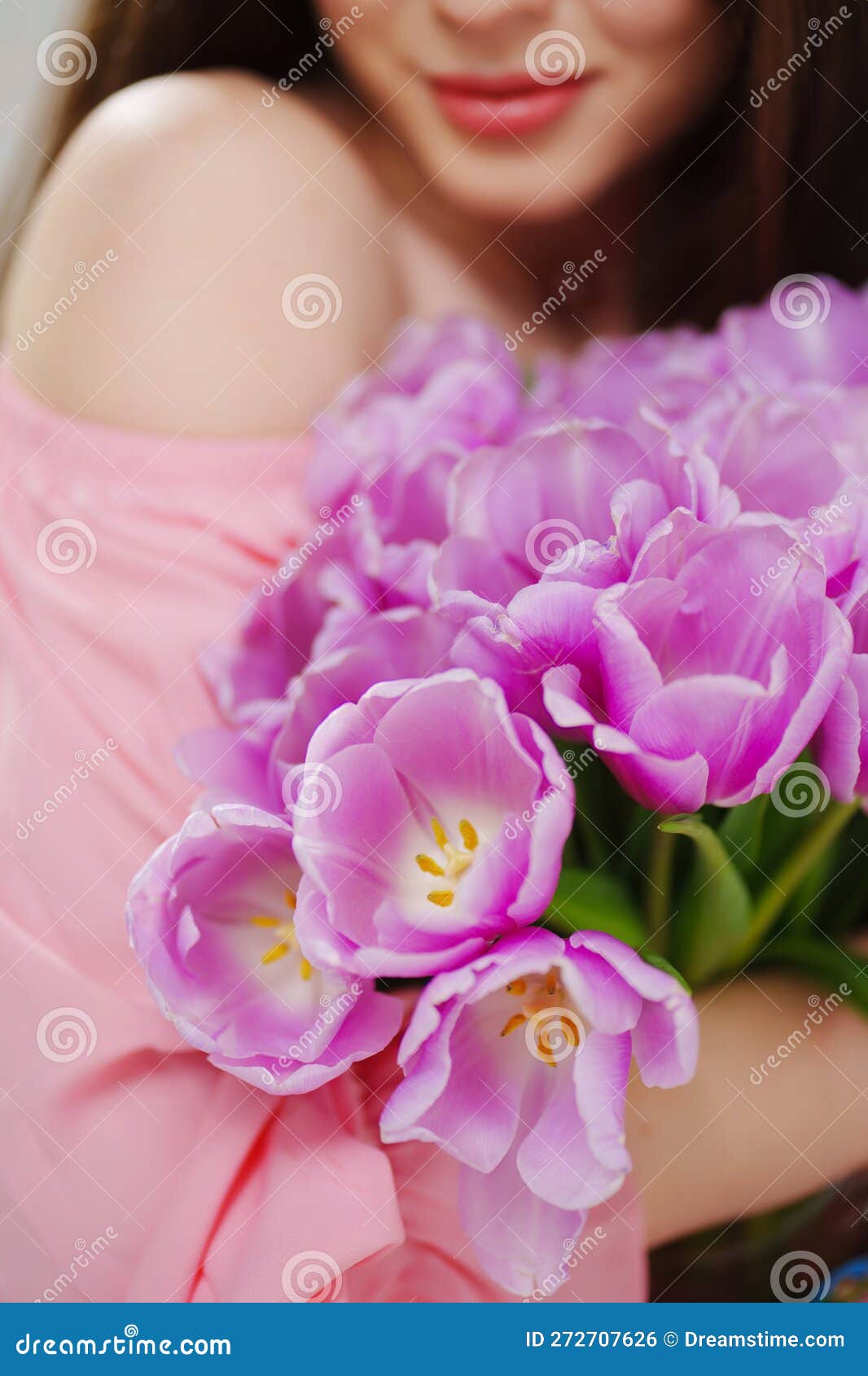 Beautiful Young Brunette Woman With Long Hair In Pink With A Bouquet Of