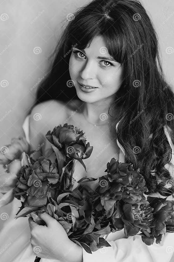 A Beautiful Young Brunette Woman In A White Shirt With A Bouquet Of