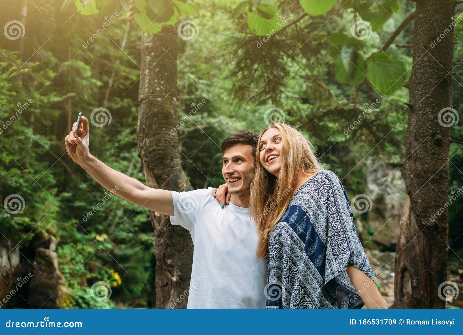 Beautiful Young Couple Exploring in the Park and Makes Selfie Stock ... Beautiful Young Couple Exploring in the Park and Makes Selfie Stock ...