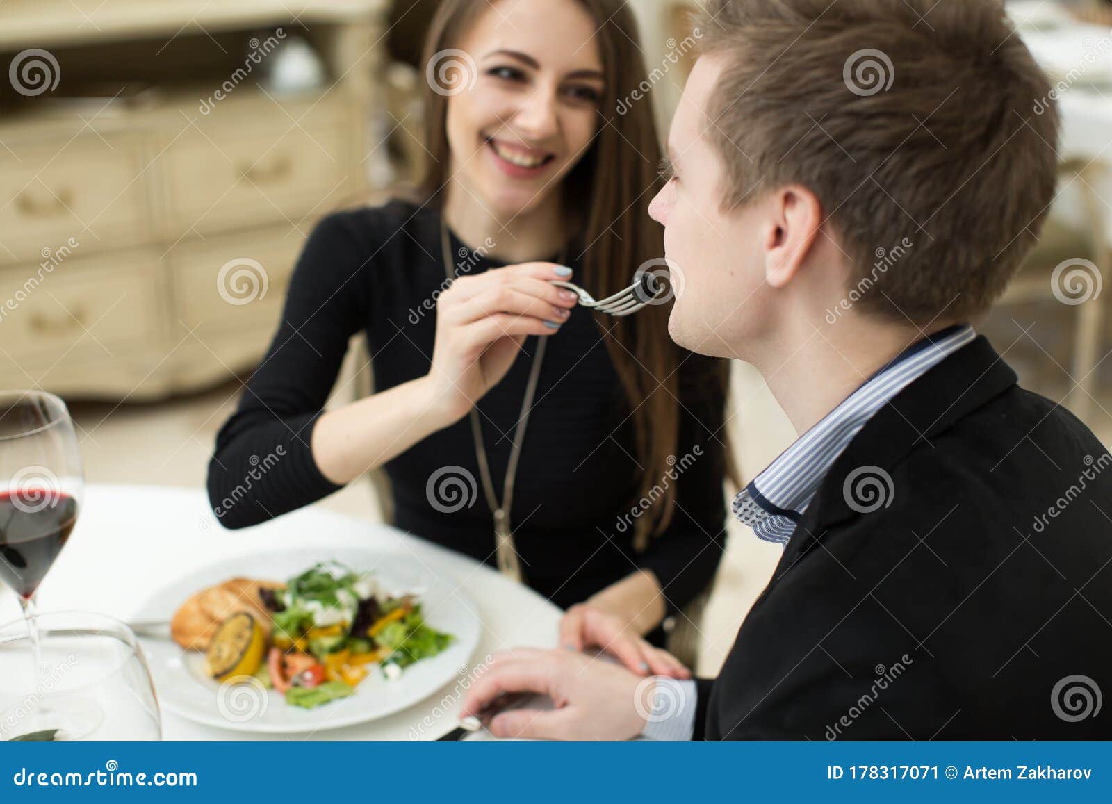 Beautiful Young Couple Feeding Each Other and Smiling while Spending ...