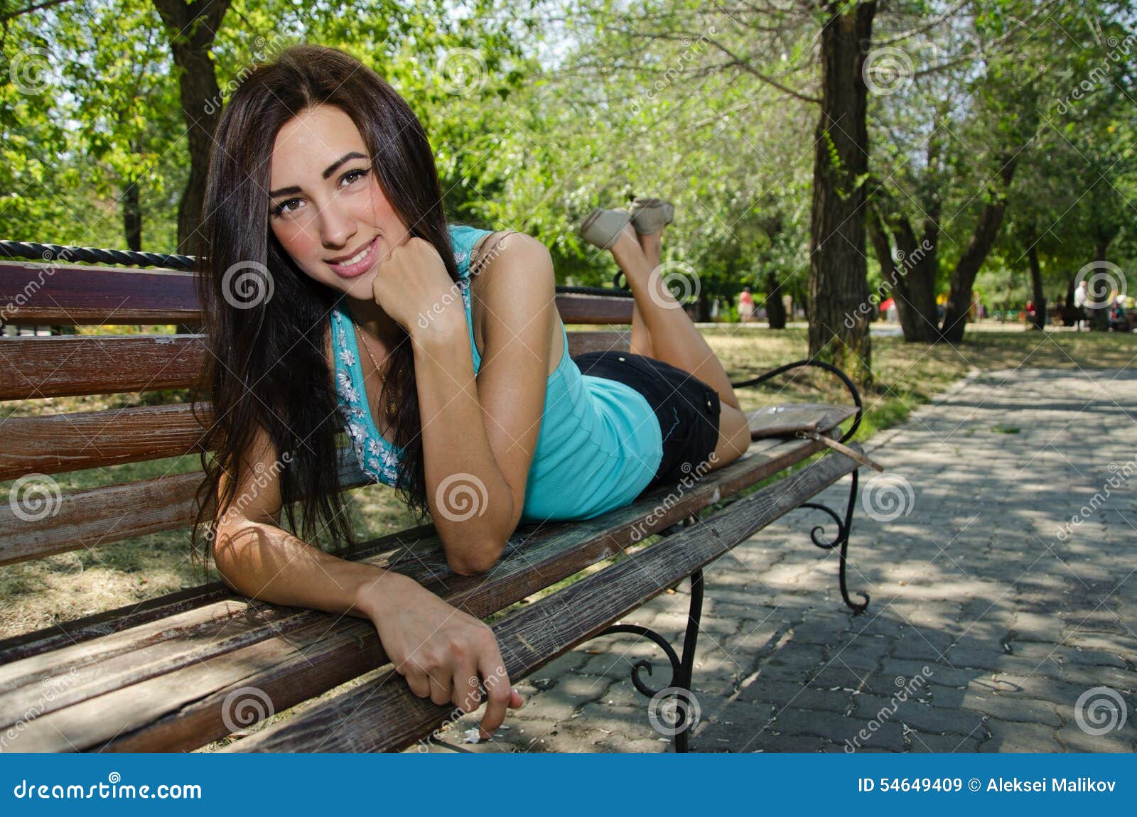 Beautiful Young Girl Lying on a Bench in the Park and Smiling Stock ...