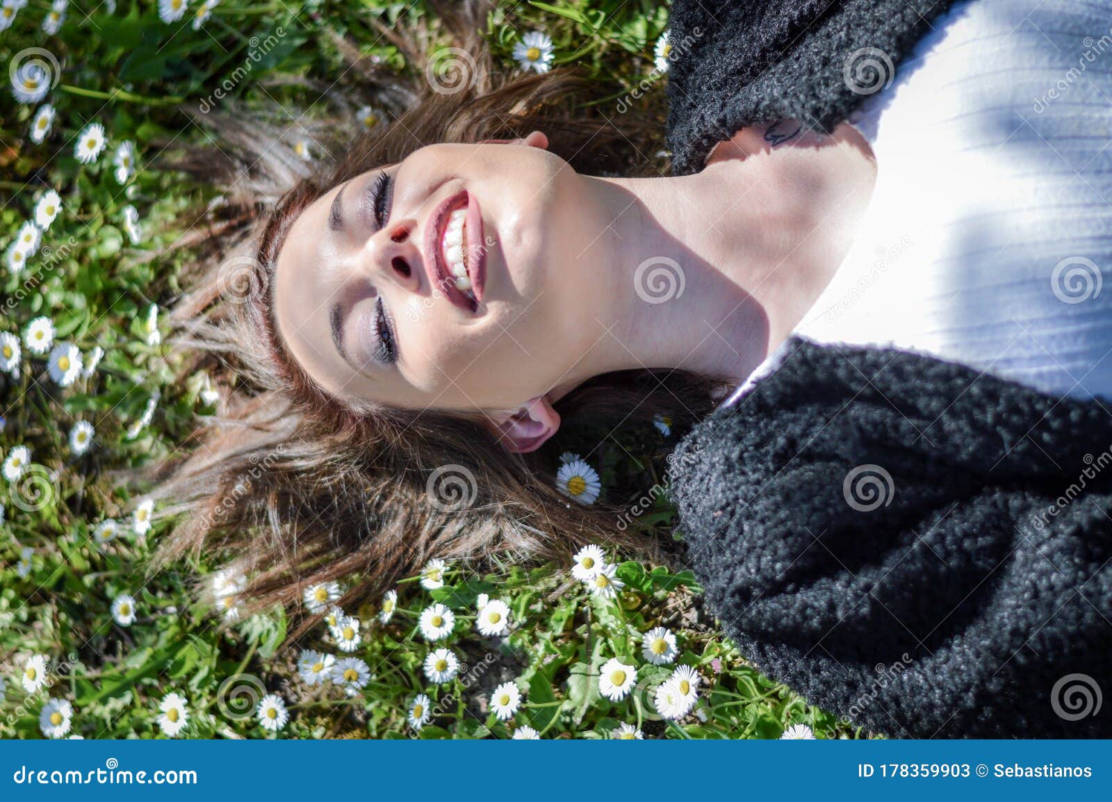 Beautiful Young Girl Lying In The Grass Full Of Daisies Stock Image
