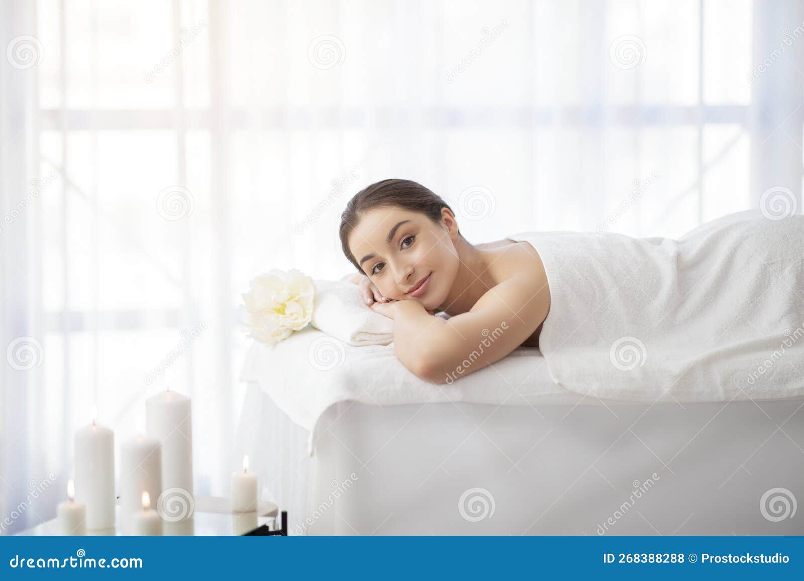 Beautiful Young Indian Woman Relaxing On Massage Table In Spa Salon