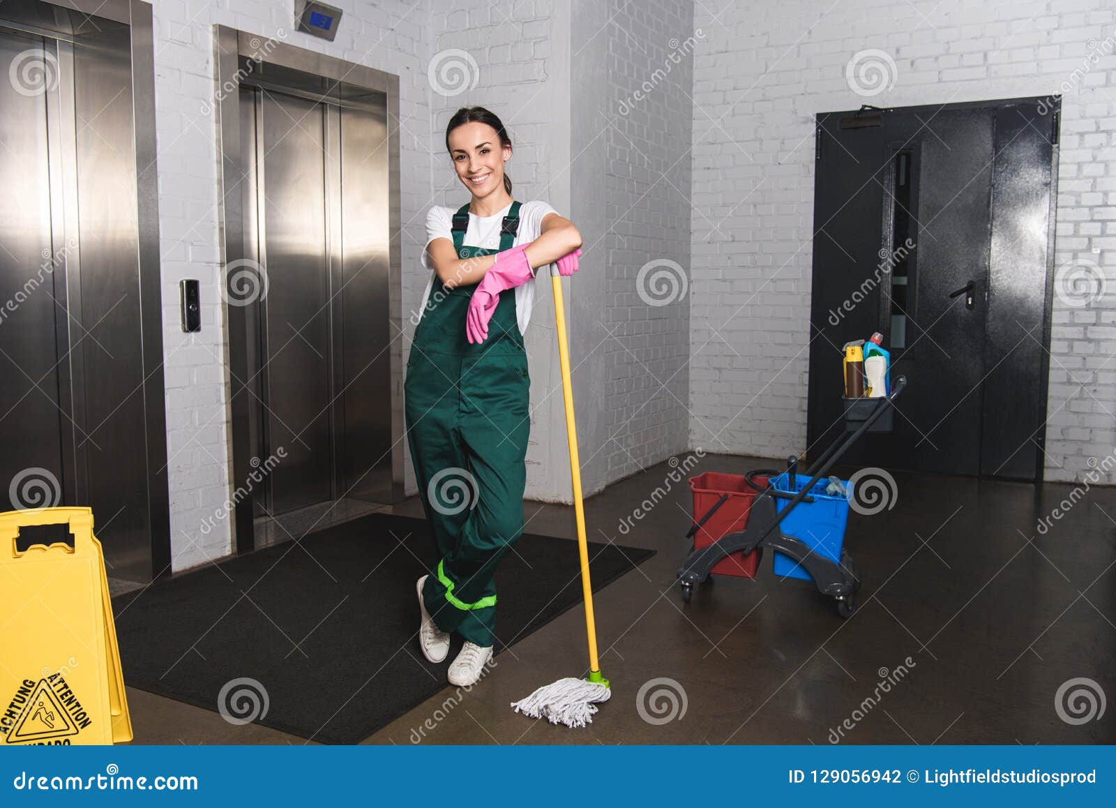 Beautiful Young Janitor Leaning at Mop and Smiling Stock Photo - Image ...