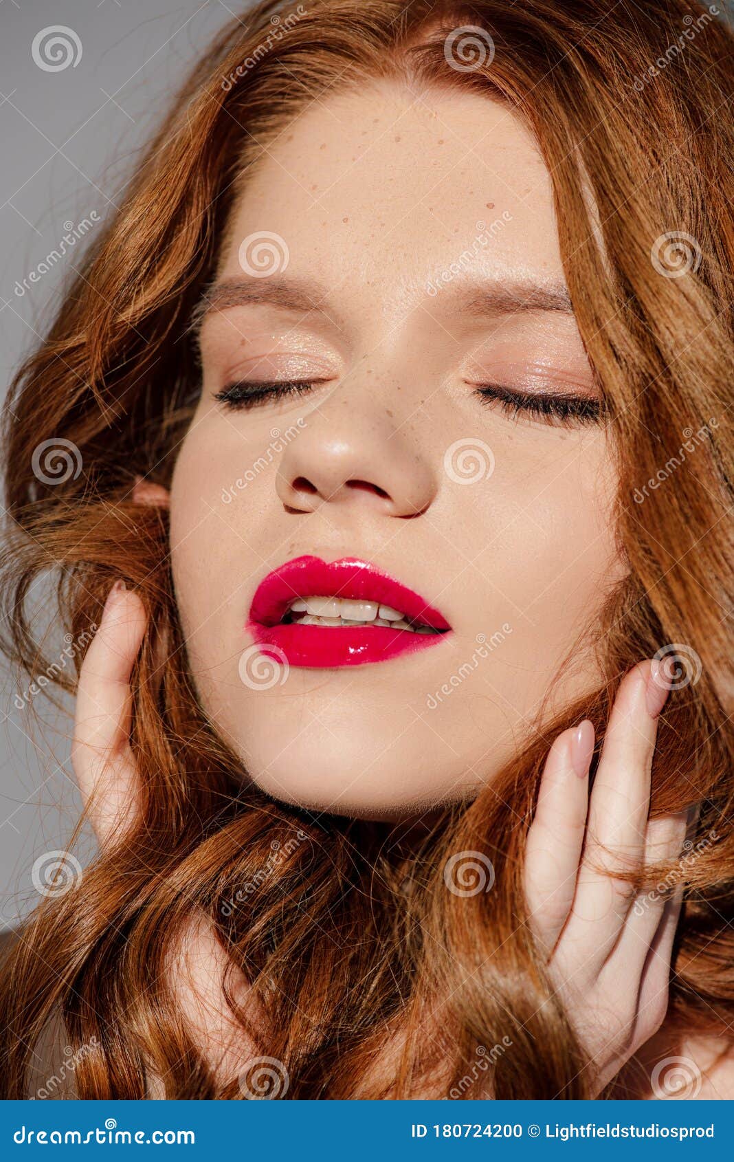Beautiful Young Redhead Woman With Red Lips Posing Isolated On Grey