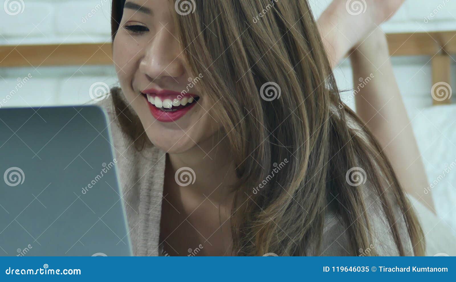 Beautiful Young Smiling Asian Woman Working On Laptop While Sitting On