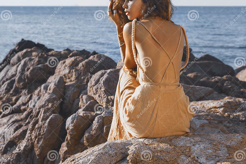 Beautiful Young Stylish Woman Sitting on the Stone at Sunset Stock ... Beautiful Young Stylish Woman Sitting on the Stone at Sunset Stock ...
