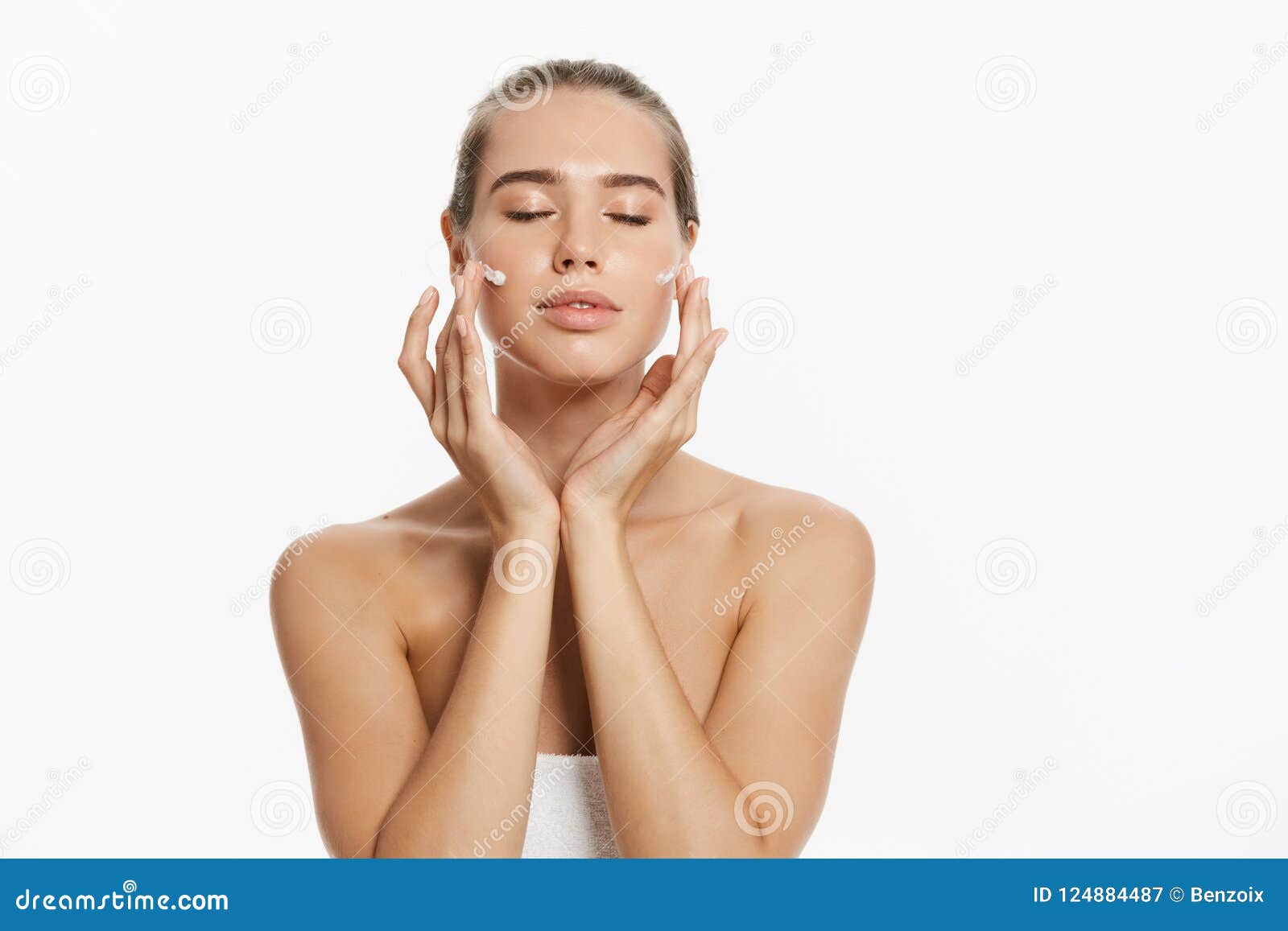 Beautiful Young Woman Applying Cosmetic Cream Treatment On Her Face