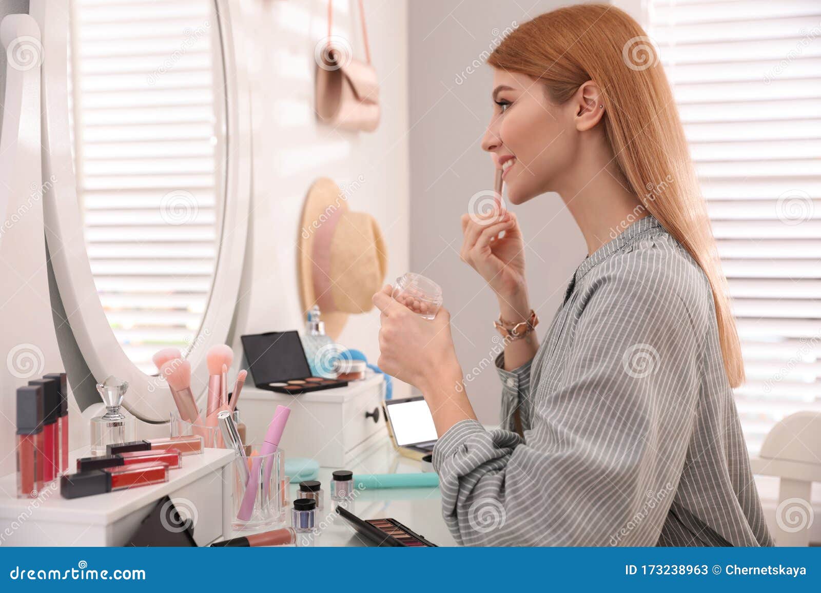Beautiful Young Woman Applying Makeup Near Mirror In Room Stock Image