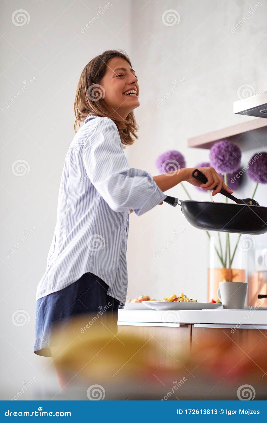 Beautiful Young Woman Laughing while Making Breakfast in Modern Kitchen ... Beautiful Young Woman Laughing while Making Breakfast in Modern Kitchen ...