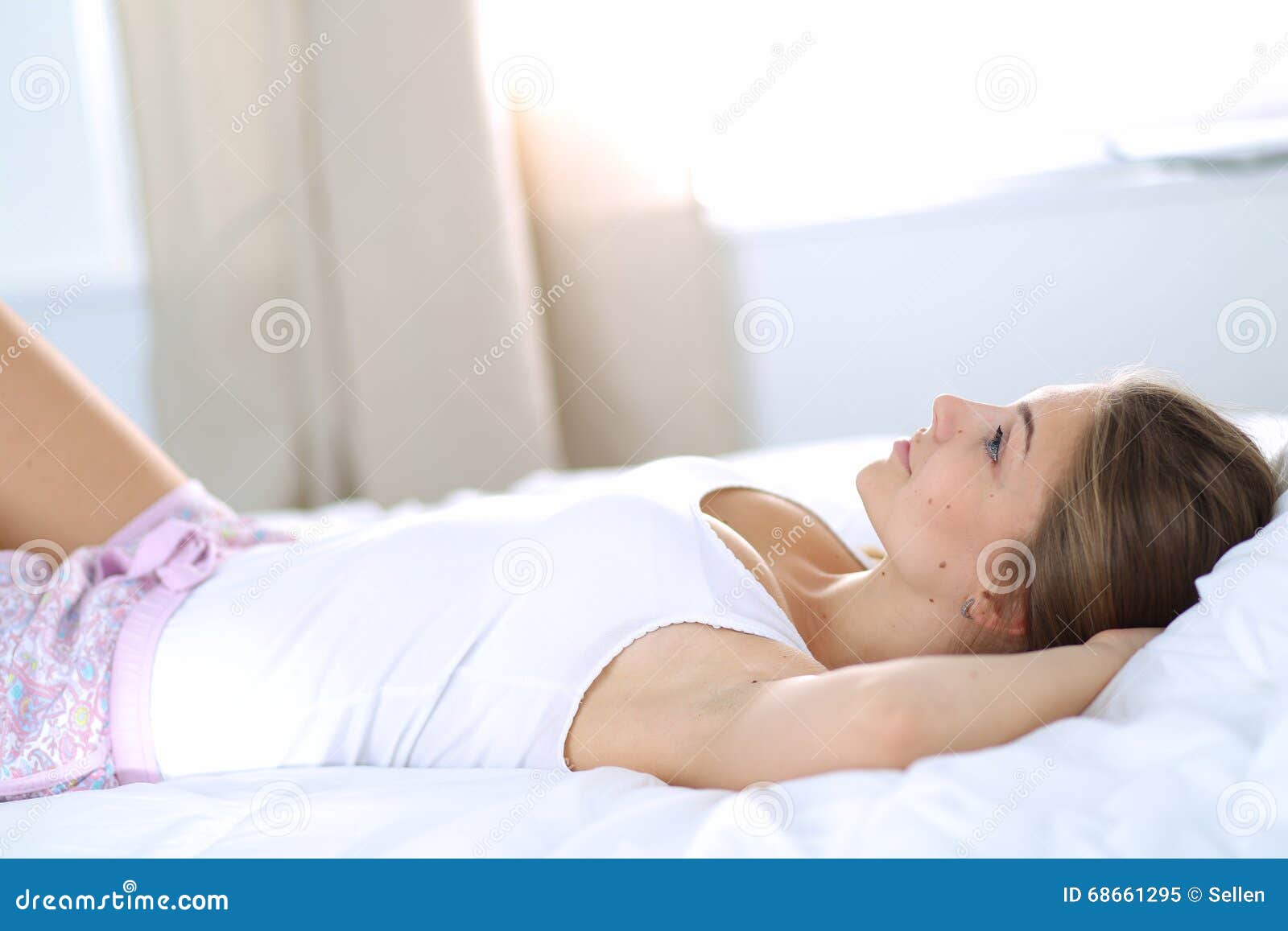 A Beautiful Young Woman Lying In Bed Comfortably And Blissfully Stock