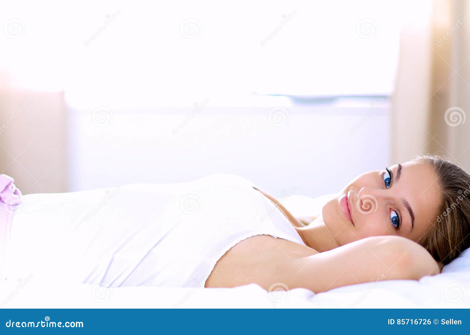 A Beautiful Young Woman Lying In Bed Comfortably And Blissfully Stock