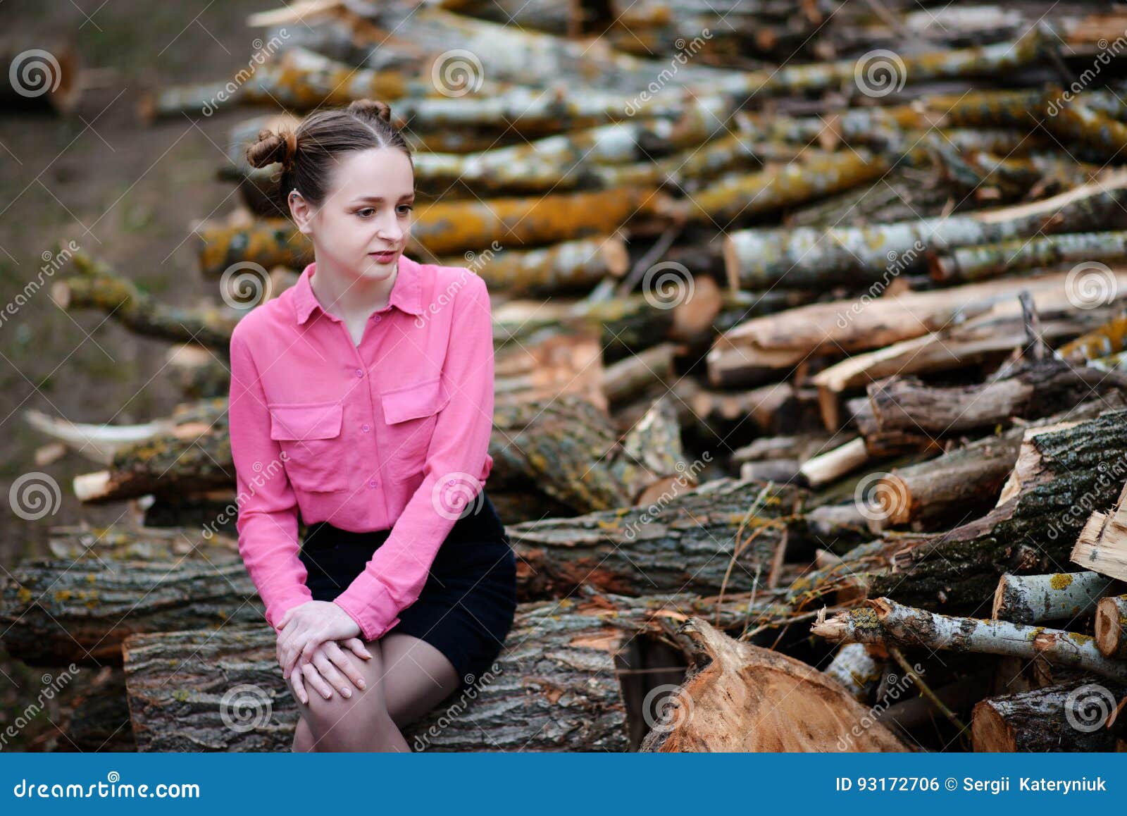 Beautiful Young Woman Sitting on Stack of Felled Tree Trunks in the ...