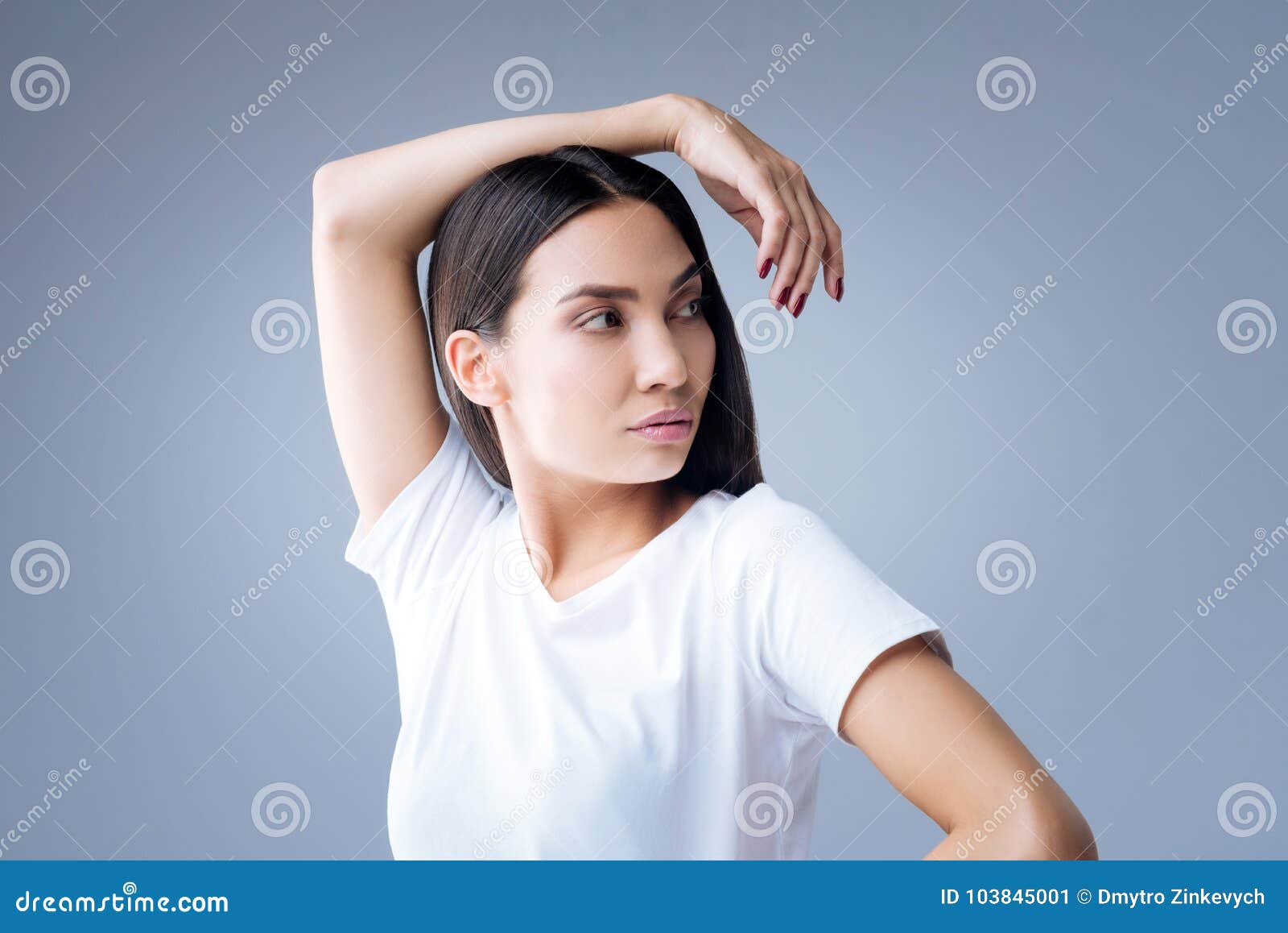 Beautiful Young Woman Standing With Her Arm Resting On The Head Stock