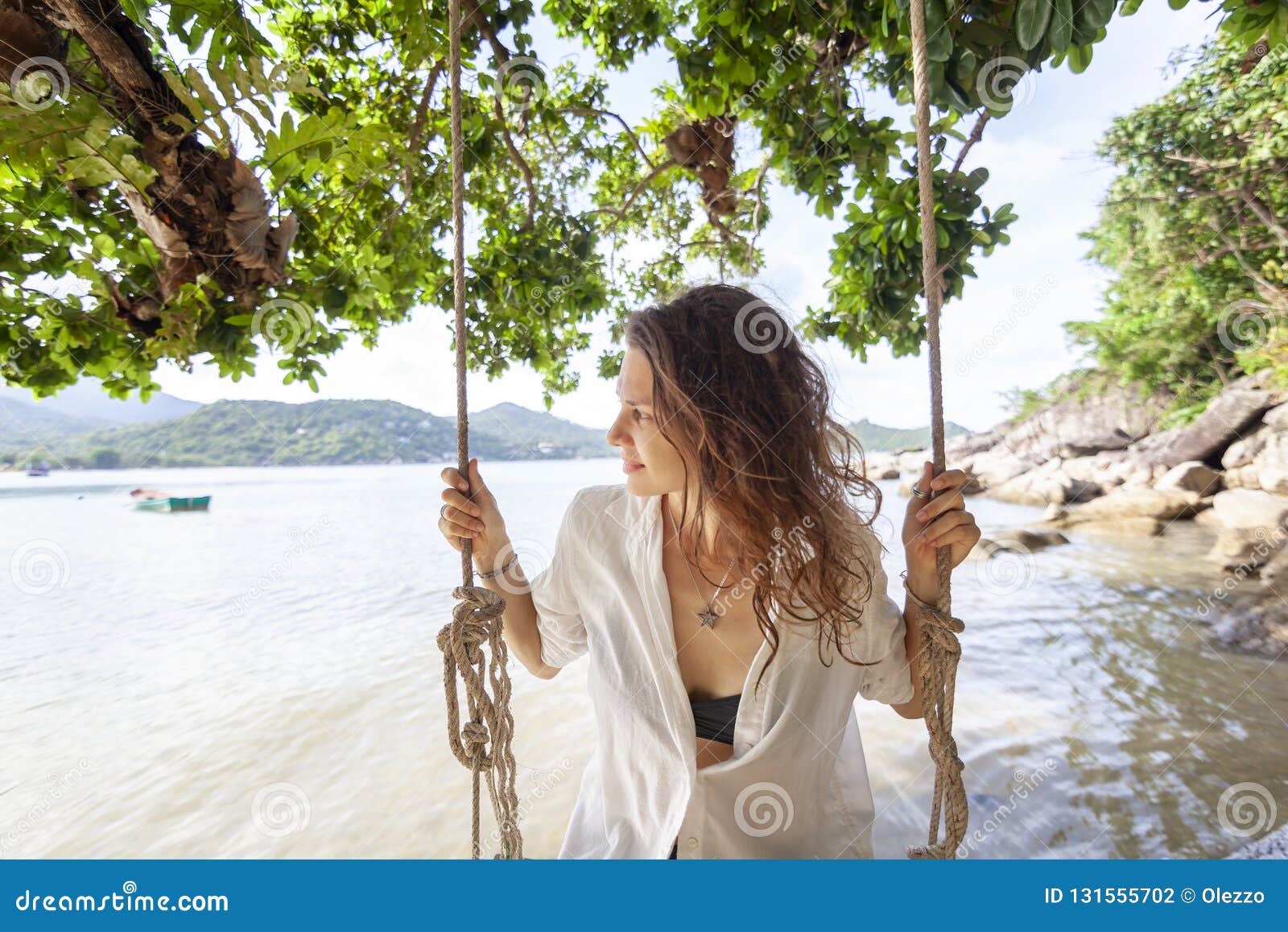 Beautiful Young Woman Traveler Swinging On A Swing On A Tropical Island