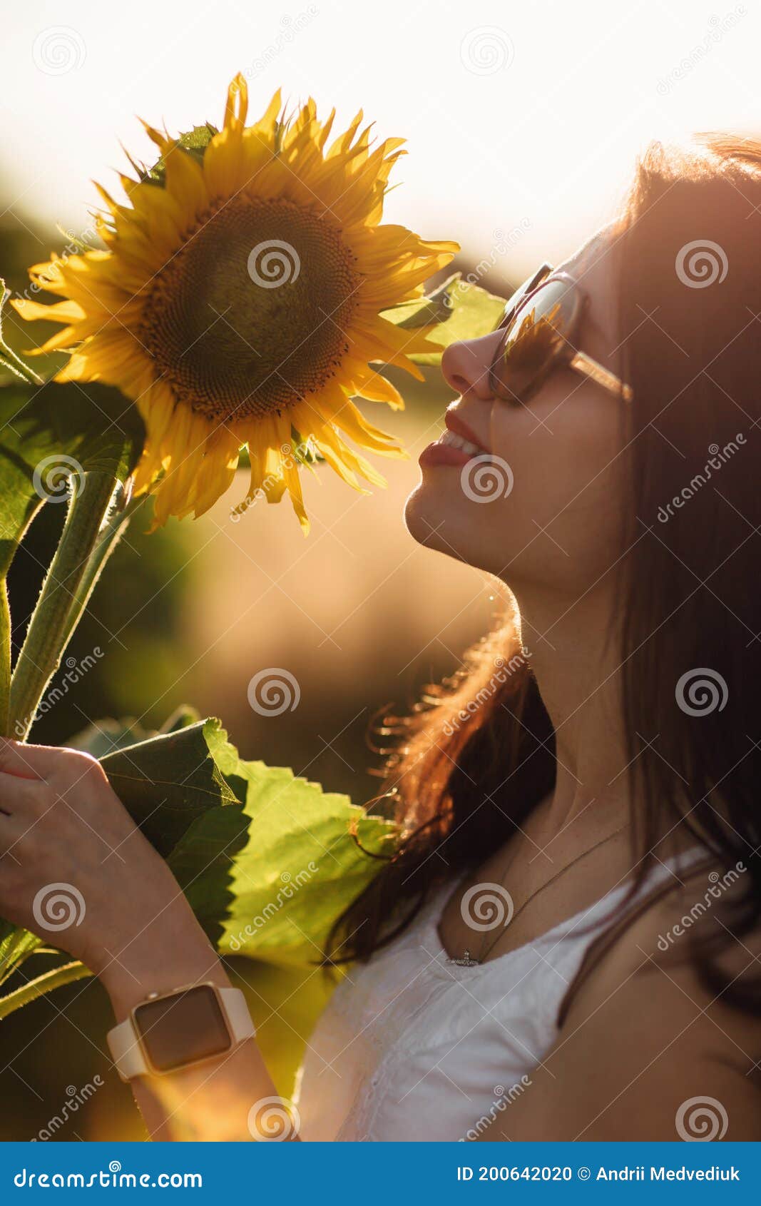 Beautiful Young Woman In A White Dress And In Sunglasses In A Field
