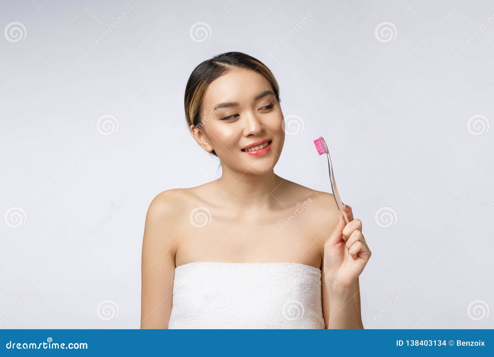 Beautiful Young Woman On White Isolated Background Holds A Toothbrush