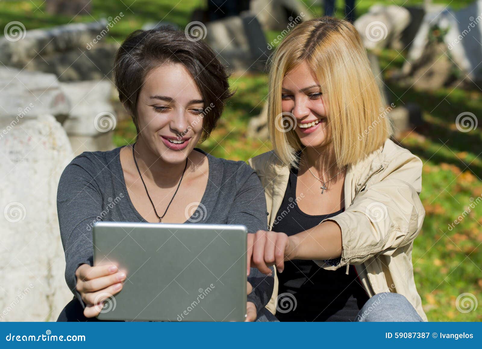 Beautiful Young Women Using Tablet Outside. Stock Image - Image of ...