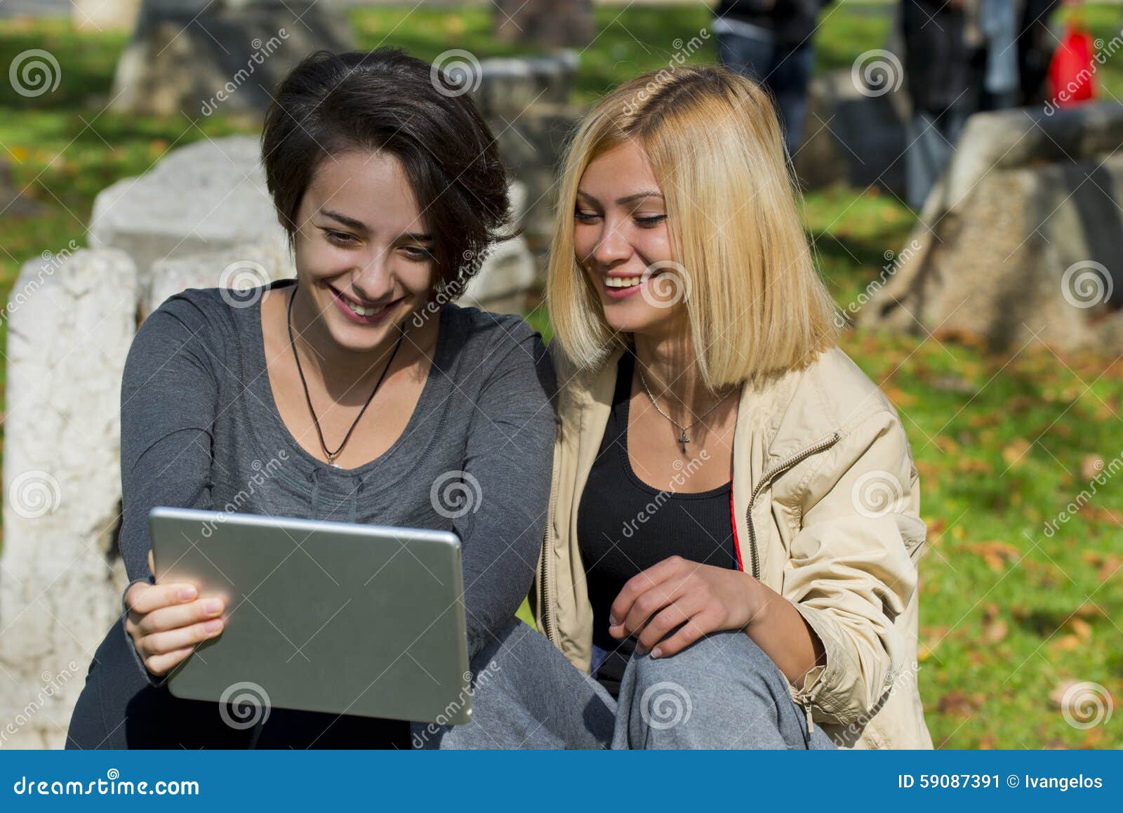 Beautiful Young Women Using Tablet Outside. Stock Image - Image of ...