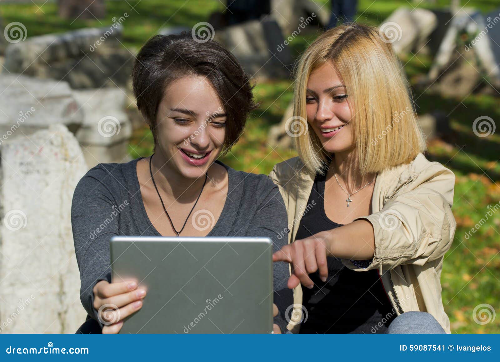 Beautiful Young Women Using Tablet Outside. Stock Image - Image of ...