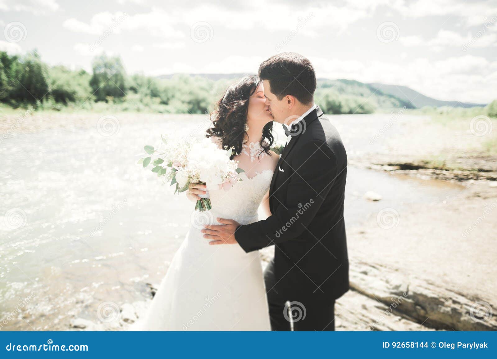 Beautifull Wedding Couple Kissing And Embracing Near The Shore Of A