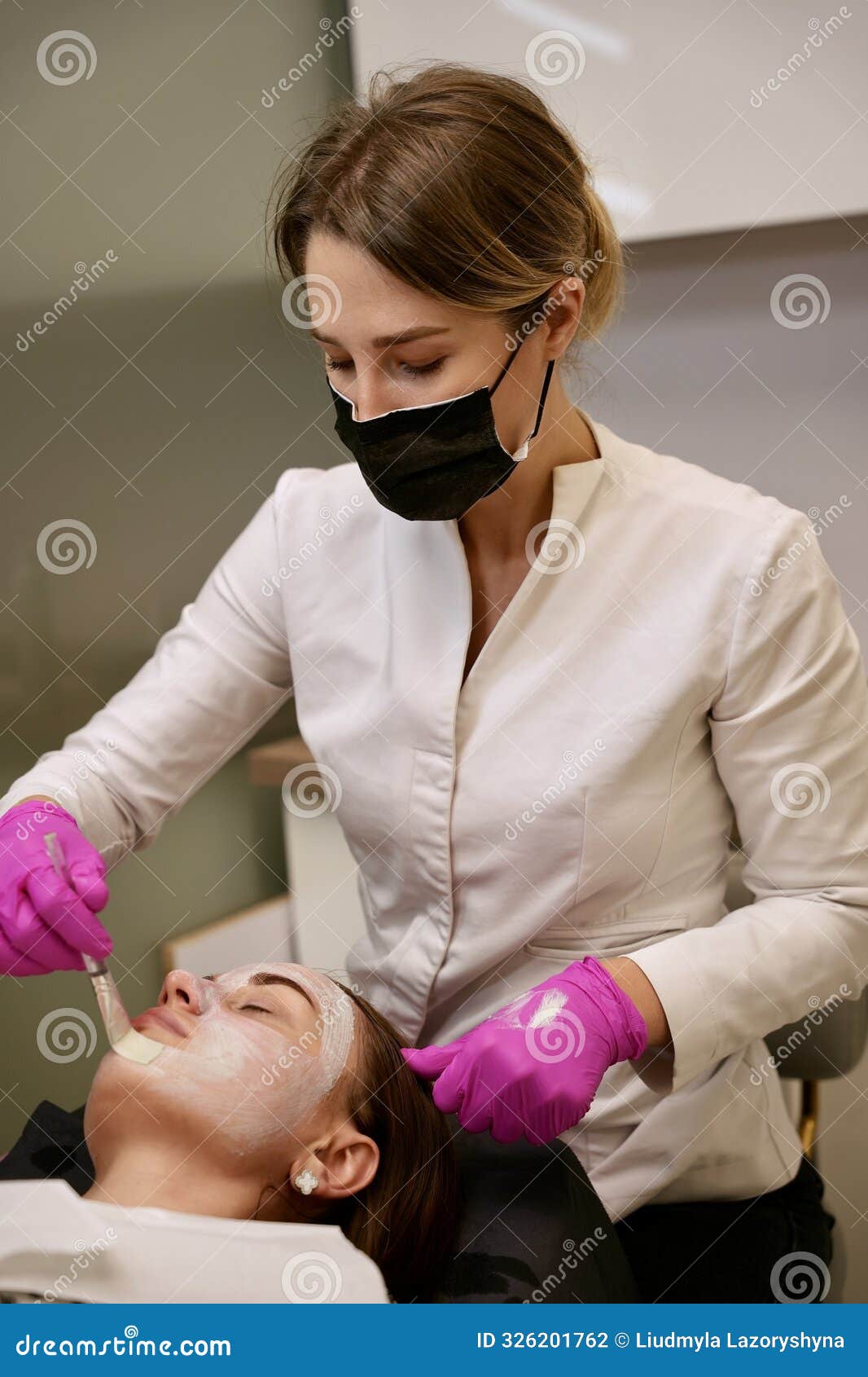 In A Beauty Salon A Cosmetologist In Pink Gloves Applies A Restorative