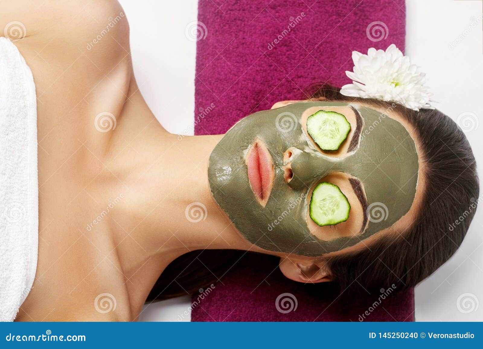 Beauty Woman With Clay Facial Mask And Cucumbers On Eyes In Beauty Spa