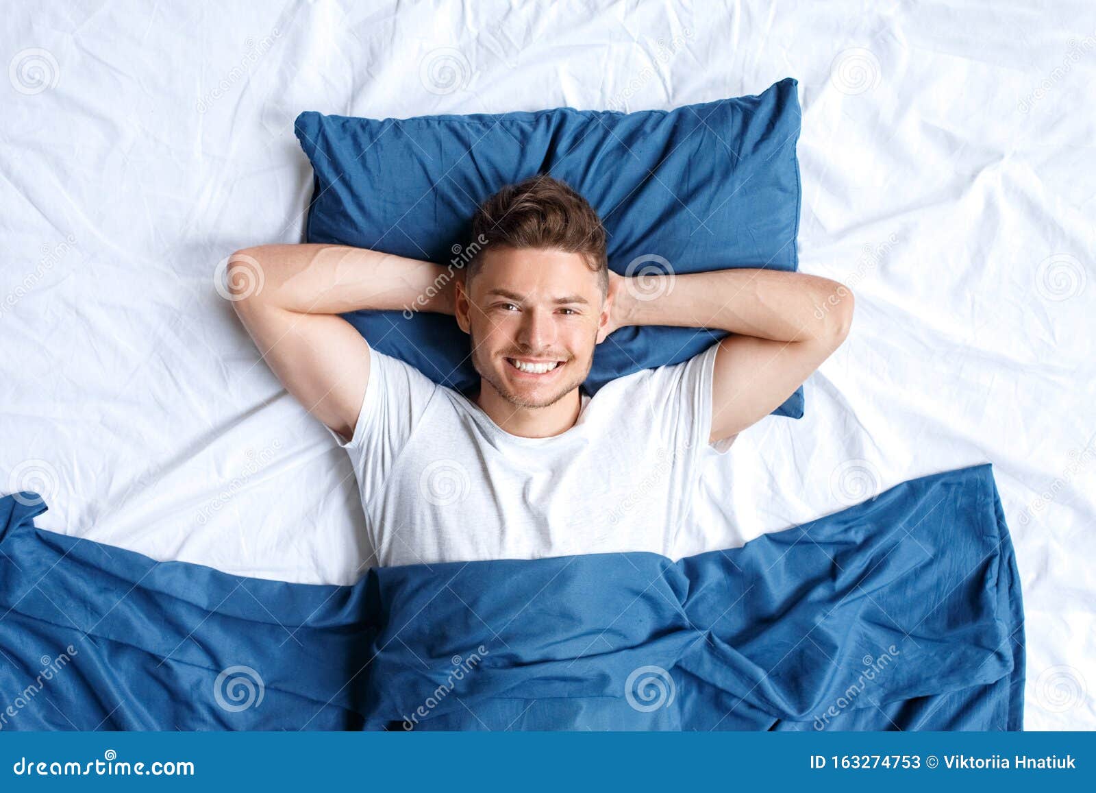 Bedtime. Guy Lying on Bed Top View Hands Under Head Smiling Relaxed ... Bedtime. Guy Lying on Bed Top View Hands Under Head Smiling Relaxed ...