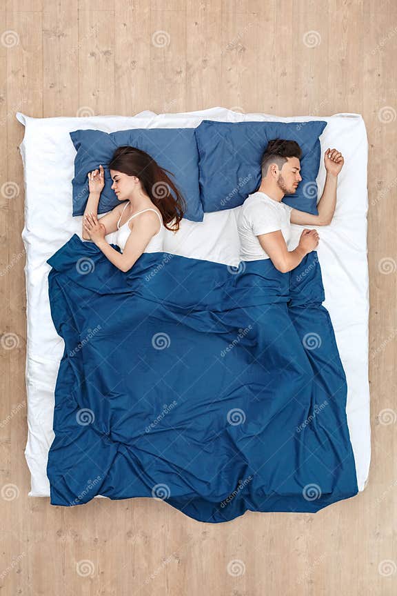 Bedtime Young Couple Sleeping On Different Sides On Bed Under Blanket