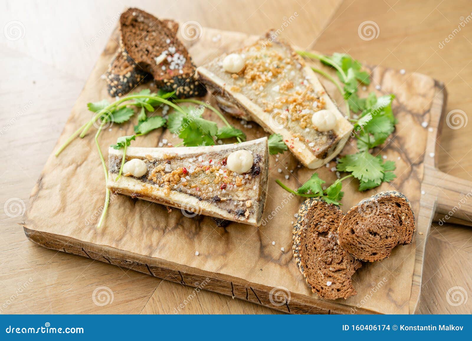 Beef Bone Marrow With Chimichurri Sauce And Toasted Bun Served On A Chopping Wooden Board Stock