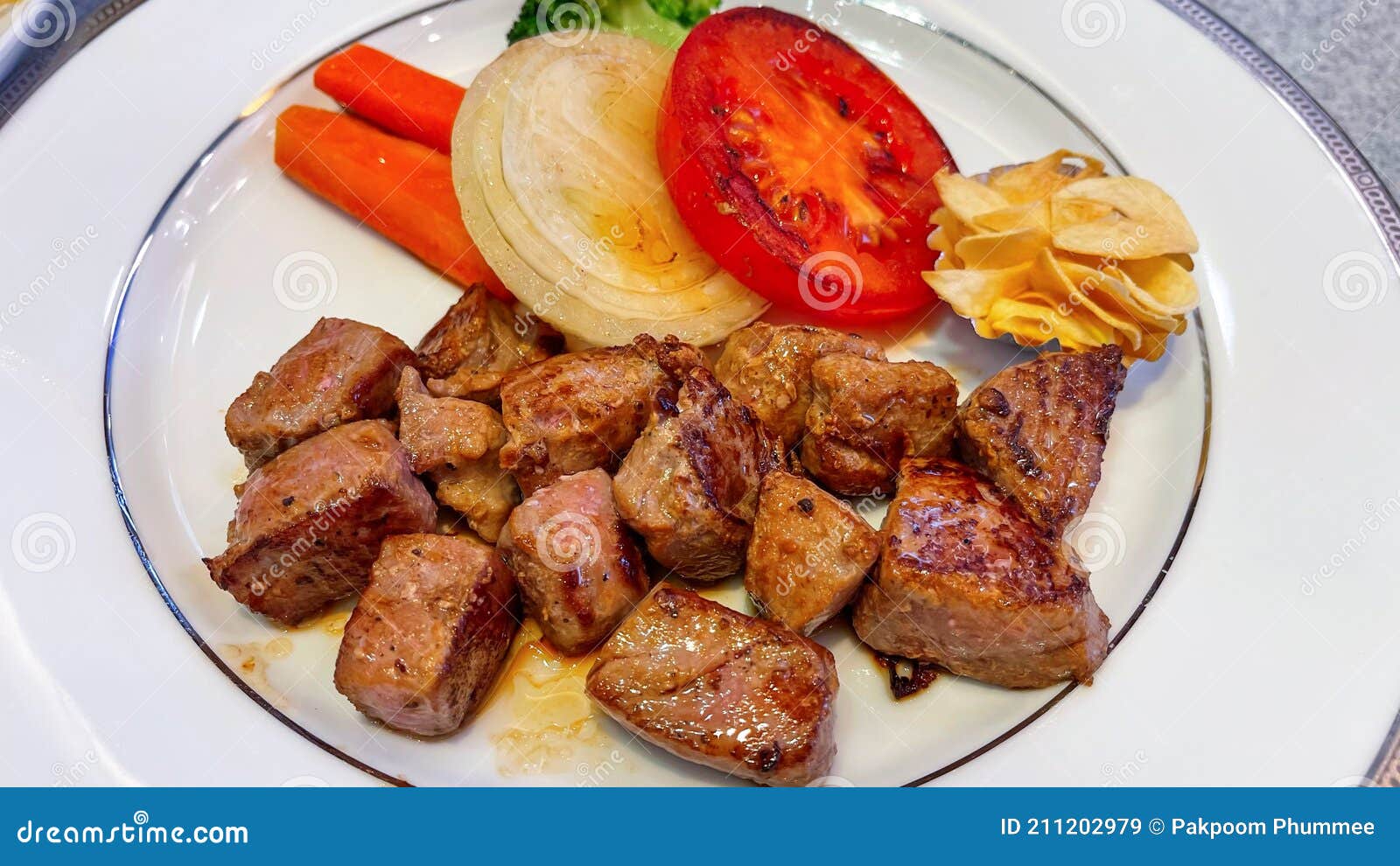 Beef Steak Cut into Squares in a Plate with Tomatoes, Onions, Carrots ...