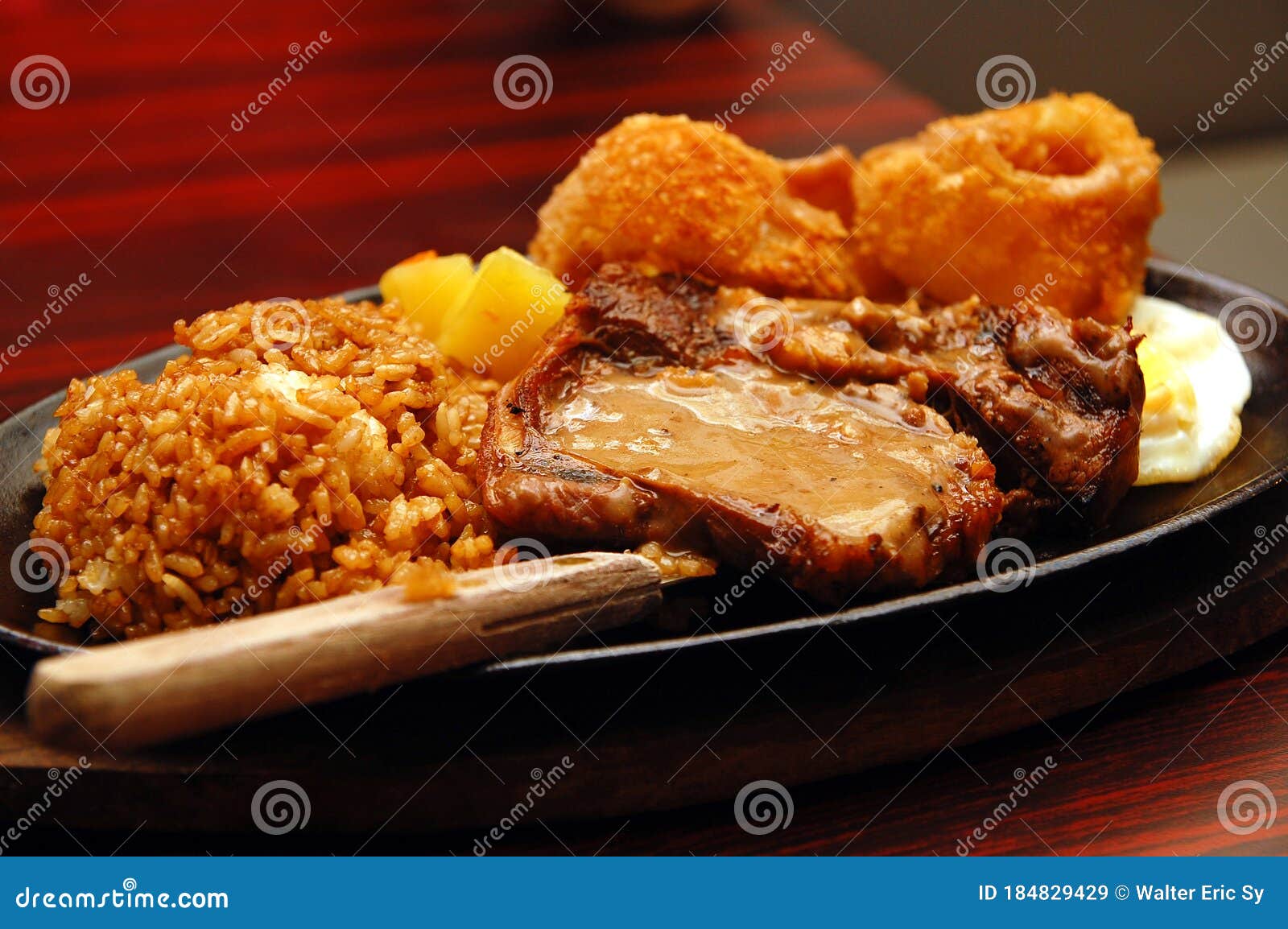 Beef Steak with Onion Rings and Rice in Sizzling Plate Stock Image ...