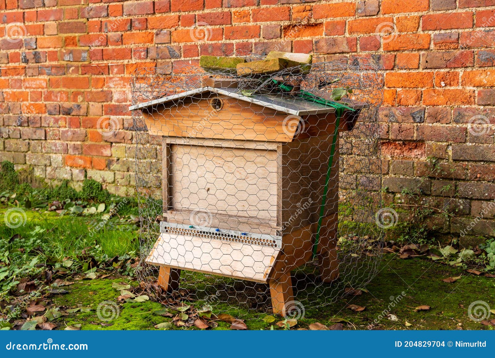 A Beehive Stands in Front of a Brick Wall Stock Photo - Image of farm ...