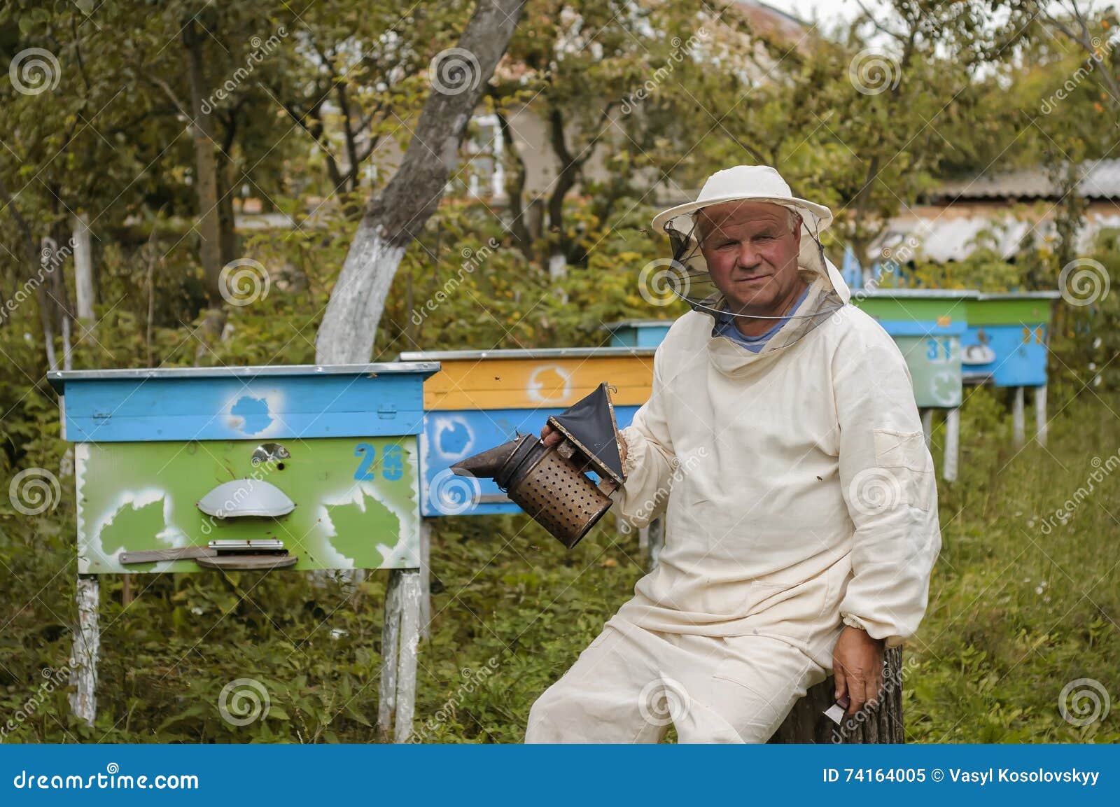 Beekeeper in Protective Clothing Holding Smoker while Standing at ...