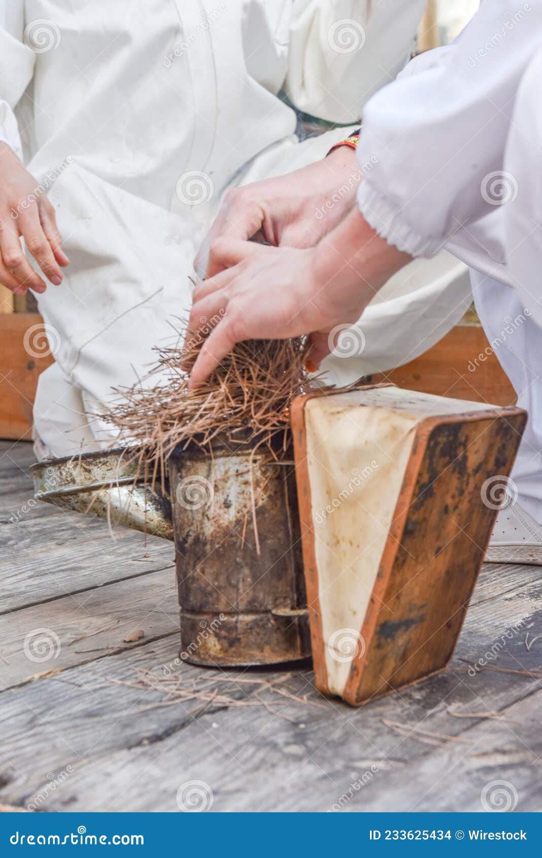 Beekeeper& X27;s Hands Preparing Bee Smoker, Bellows in Foreground and ... Beekeeper& X27;s Hands Preparing Bee Smoker, Bellows in Foreground and ...