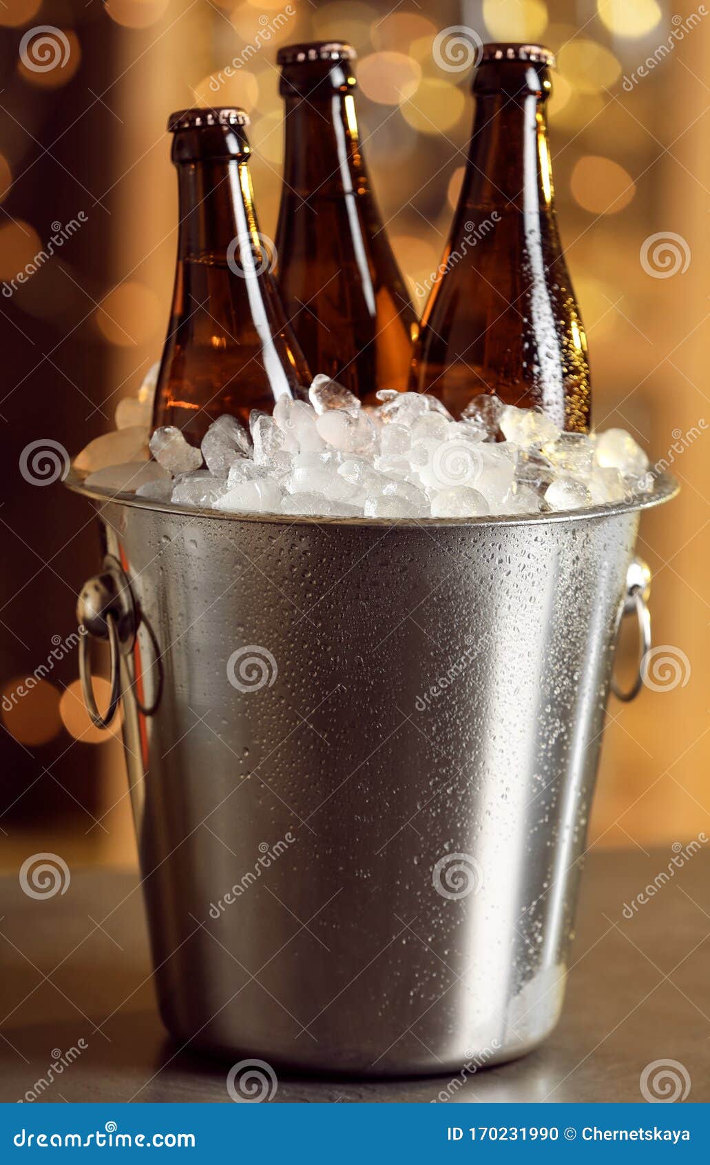 Beer in Metal Bucket with Ice on Table Against Lights Stock Photo ...