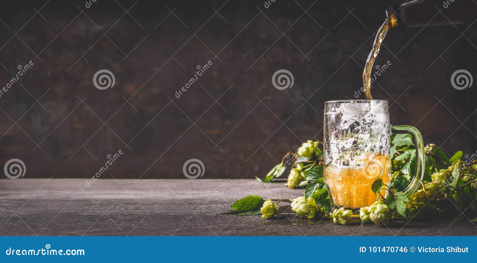 Beer is Poured into Mug on Dark Rustic Wooden Background with Hops ...