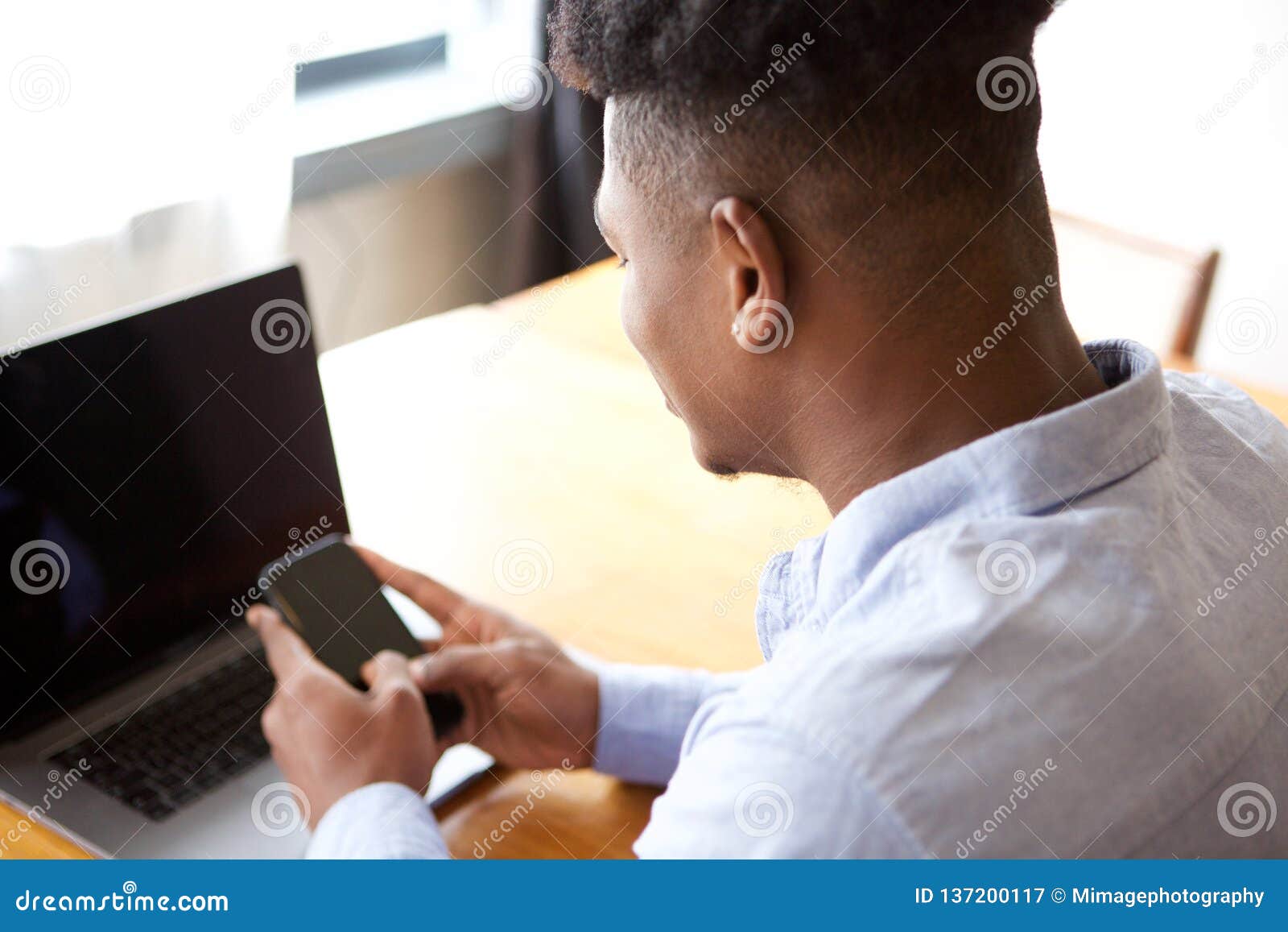 Behind of Young Man Holding Mobile Phone in Front of Laptop Computer ...