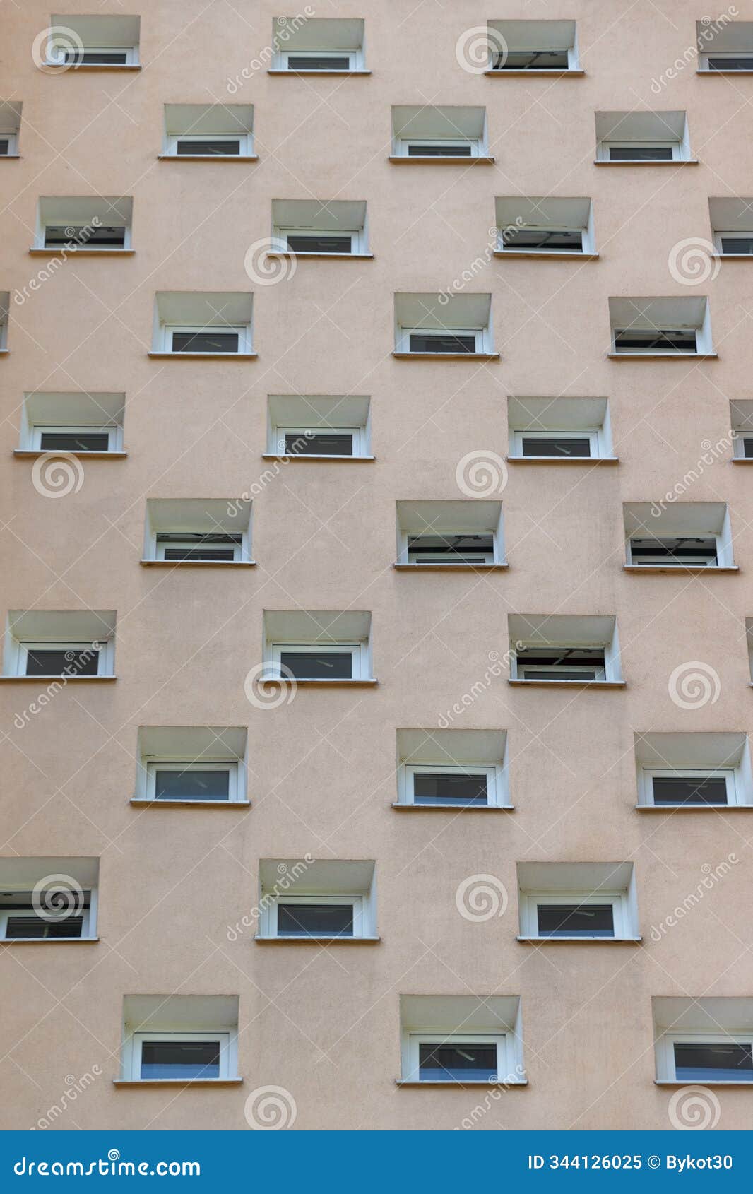 A Beige Building Facade with Small, Uniformly Arranged Square Windows ...
