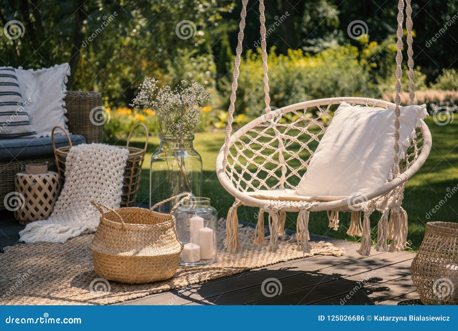 A Beige String Swing with a Pillow on a Patio. Wicker Baskets, a Stock ...