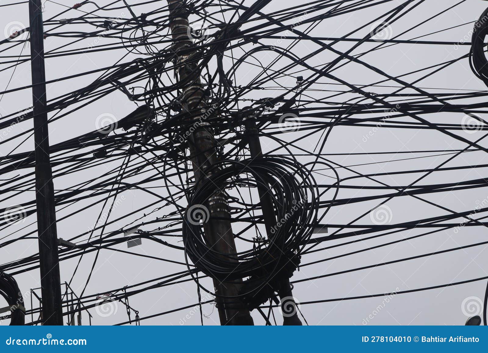 Untidy Electricity Cables Over Head With Bright Sky In The Background ...