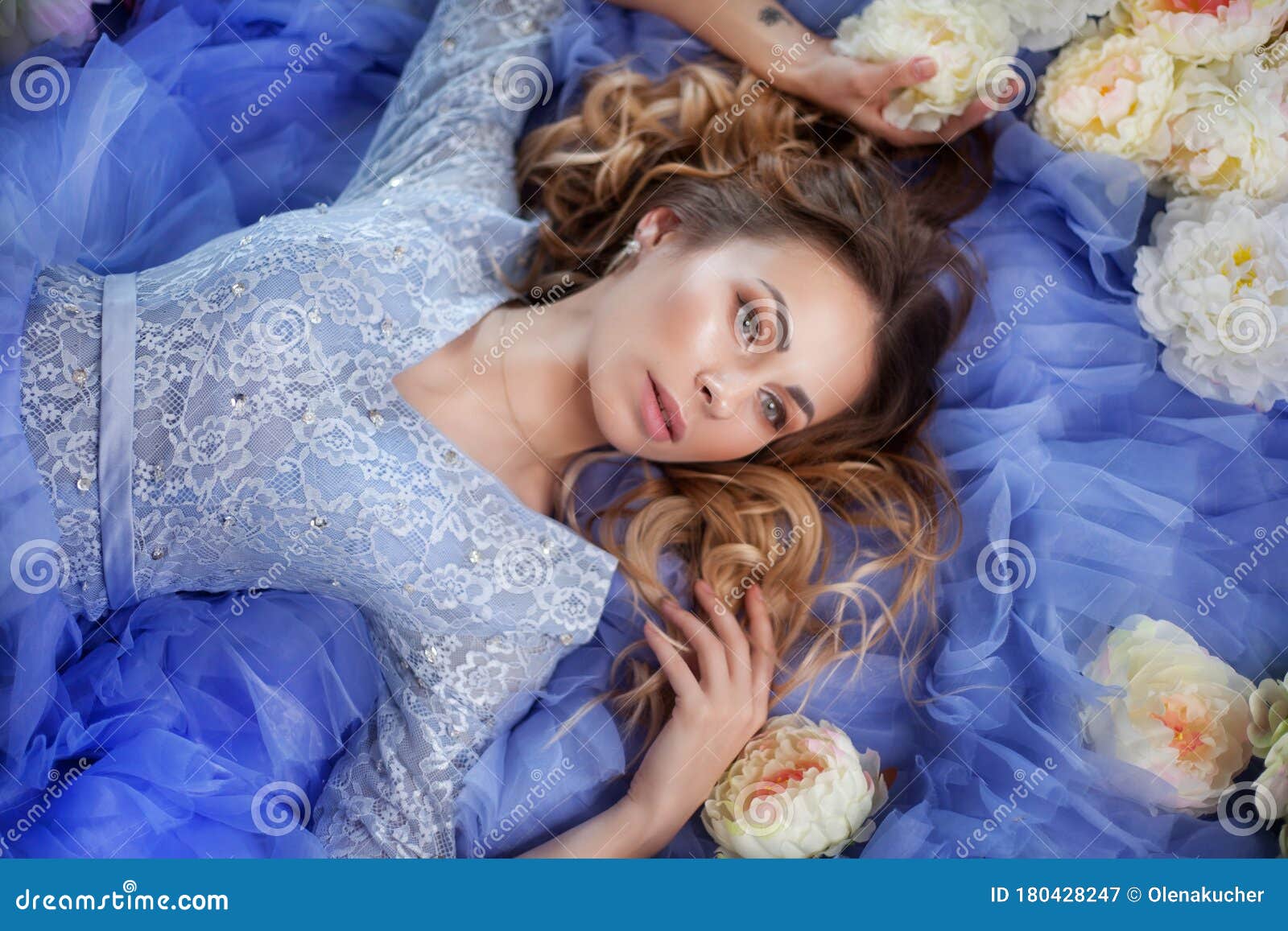 Belle Fille En Robe Bleue Sur Un Lit Avec Des Fleurs Image Stock