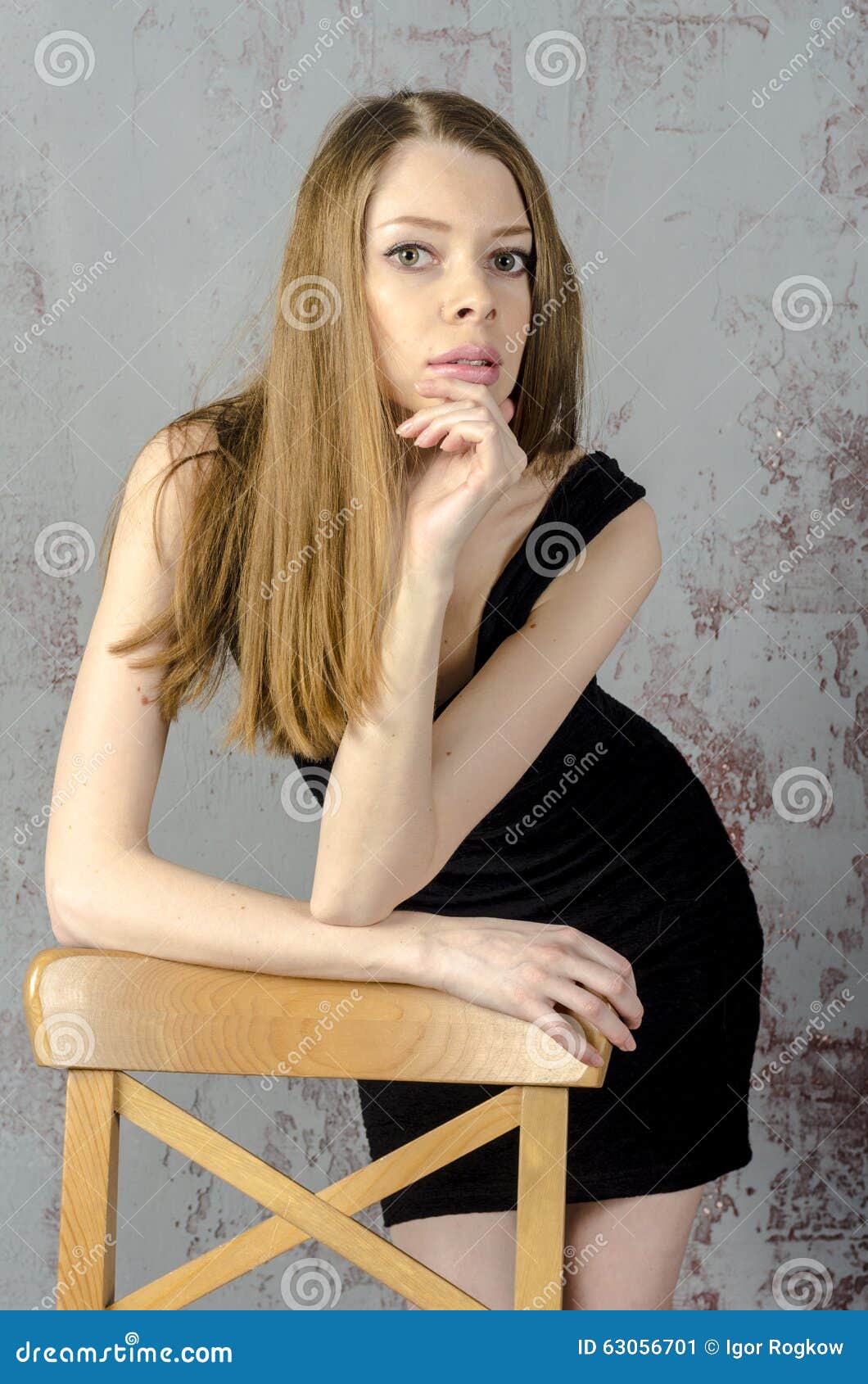 Belle Fille Rousse Mince Dans Une Mini Robe Noire Avec Une Chaise Image