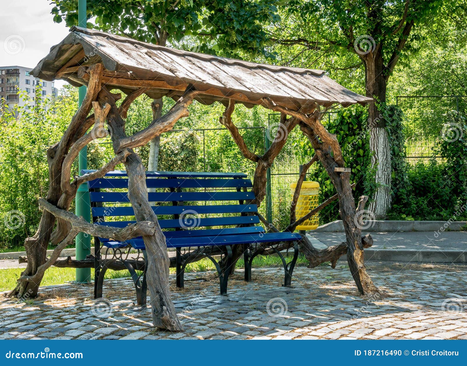 Bench in a Public Park with a Roof Made of Tree Trunks Stock Photo ...