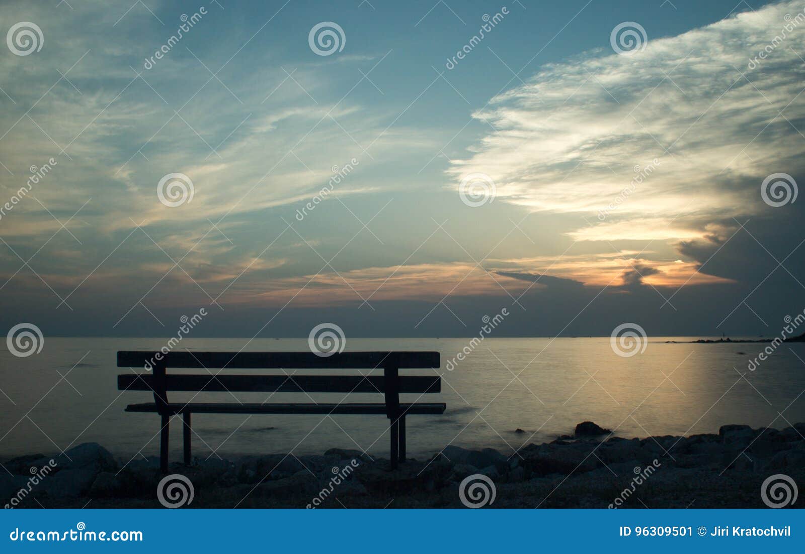 Bench by the sea at sunset stock image. Image of background - 96309501