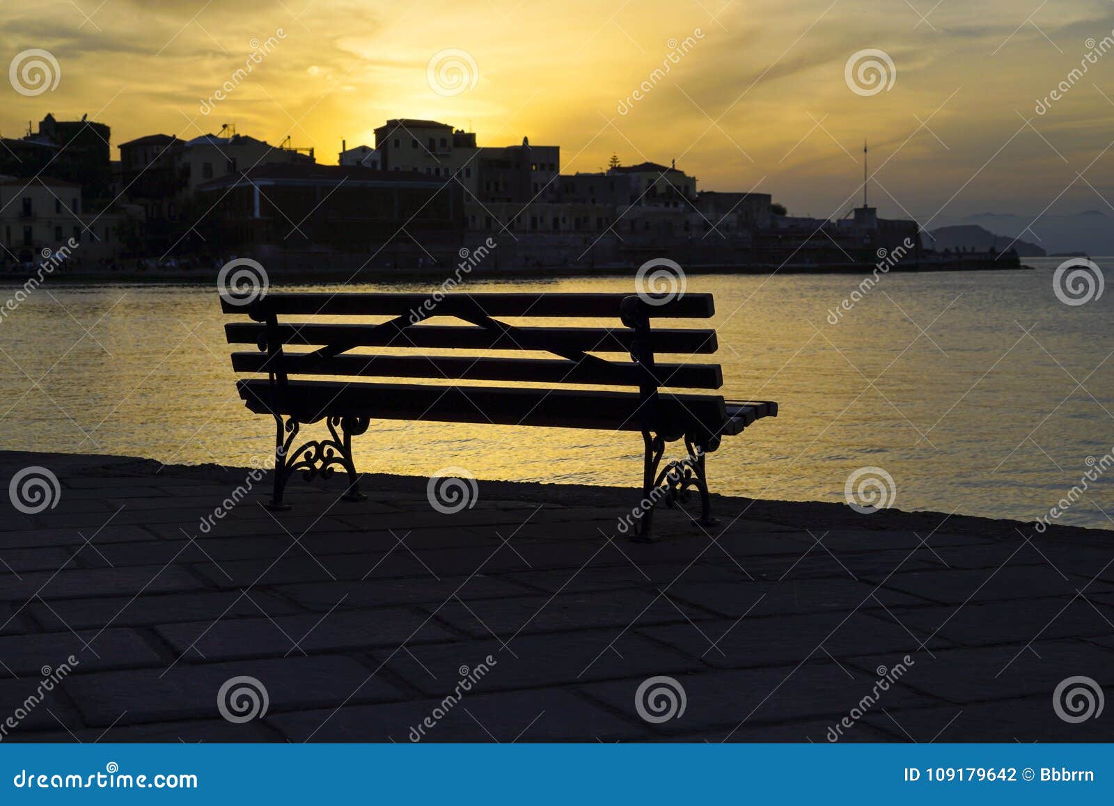 A bench by sea at sunset stock photo. Image of dramatic - 109179642