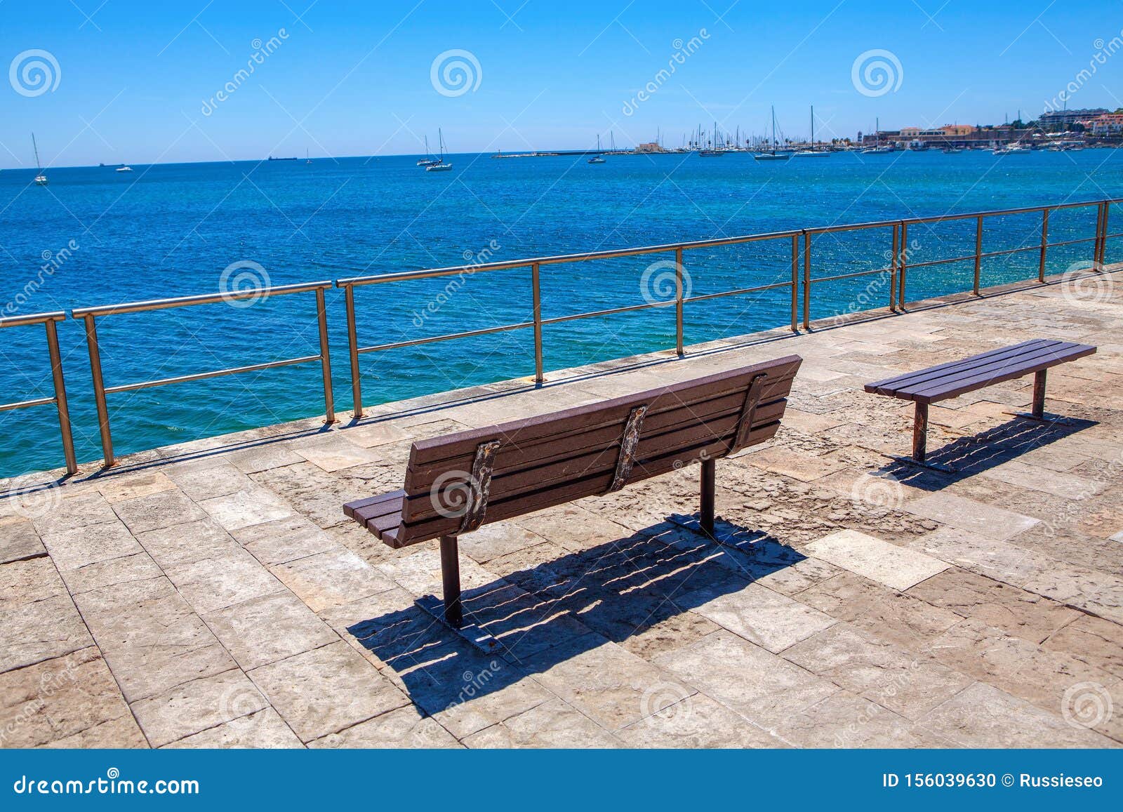 Bench on the ocean shore stock photo. Image of sailing - 156039630