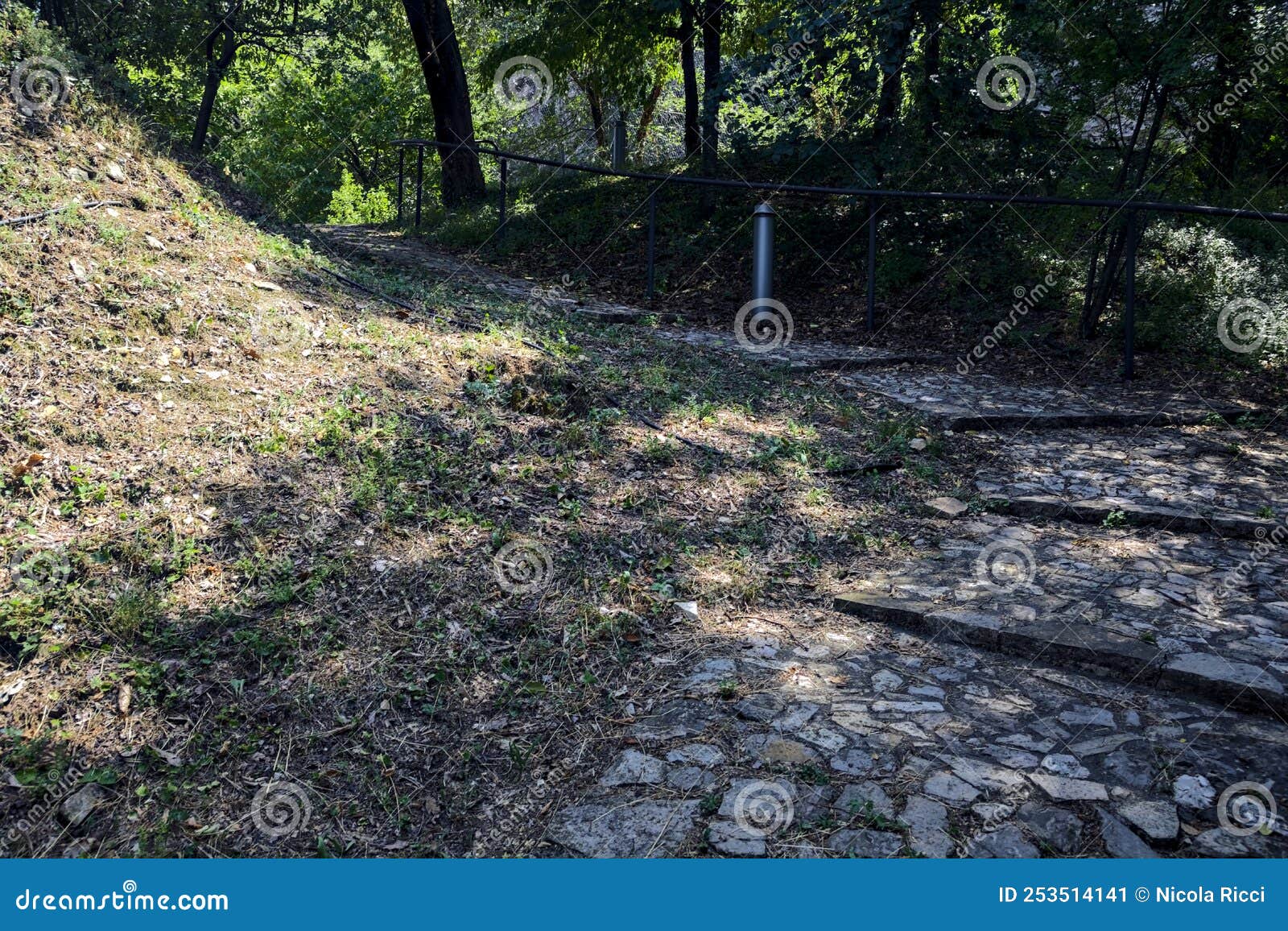 Bend in a Cobbled Path in the Shade with a Rail in a Park Stock Image ...