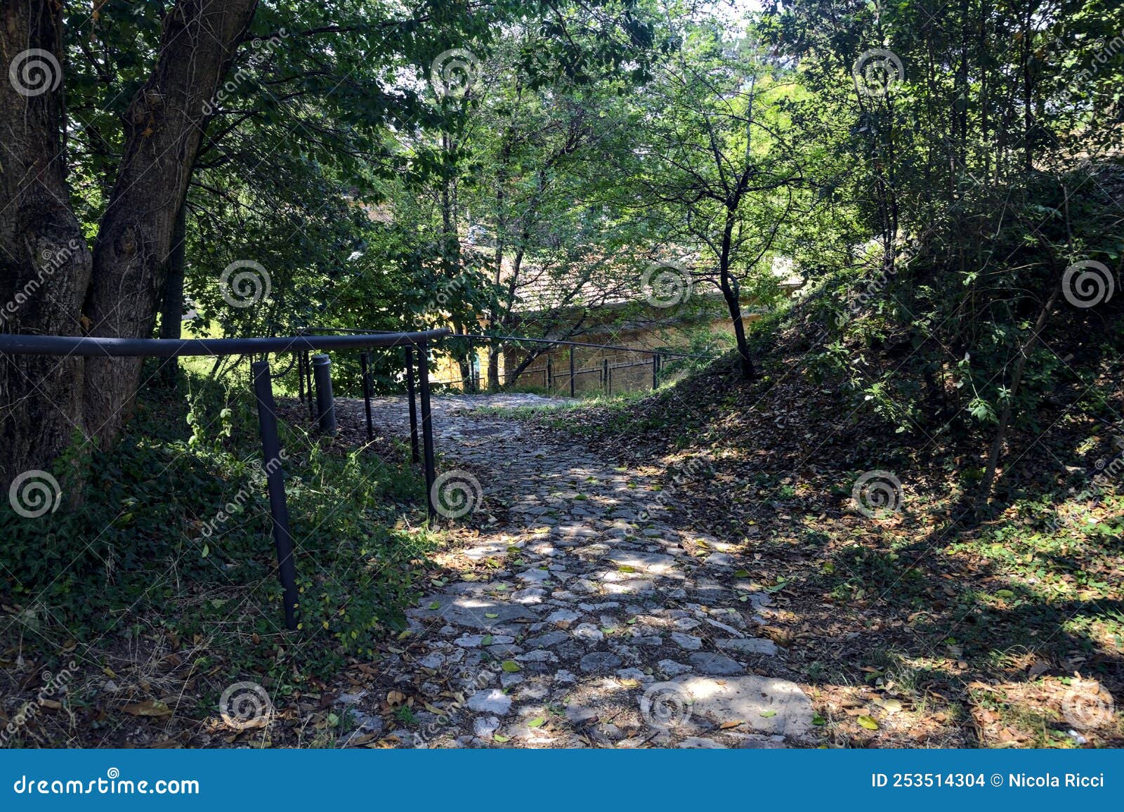 Bend in a Cobbled Path in the Shade with a Rail in a Park Stock Photo ...