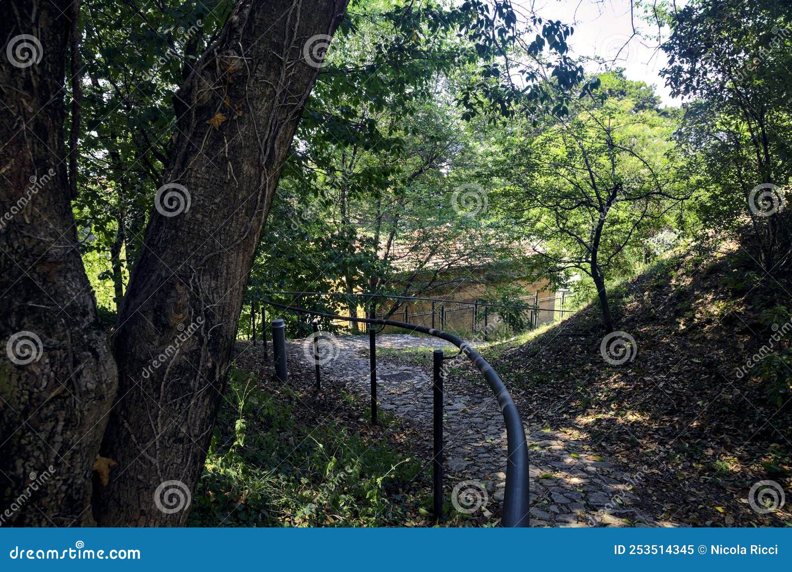 Bend in a Cobbled Path in the Shade with a Rail in a Park Stock Image ...